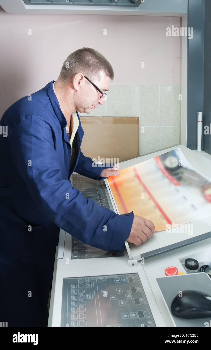 Printer checking a print run at table Stock Photo - Alamy