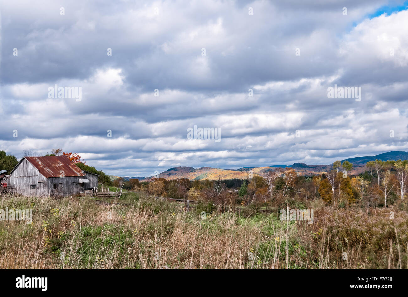 autumnal scenic view with old rustic barn with silo in Quebec Country ...