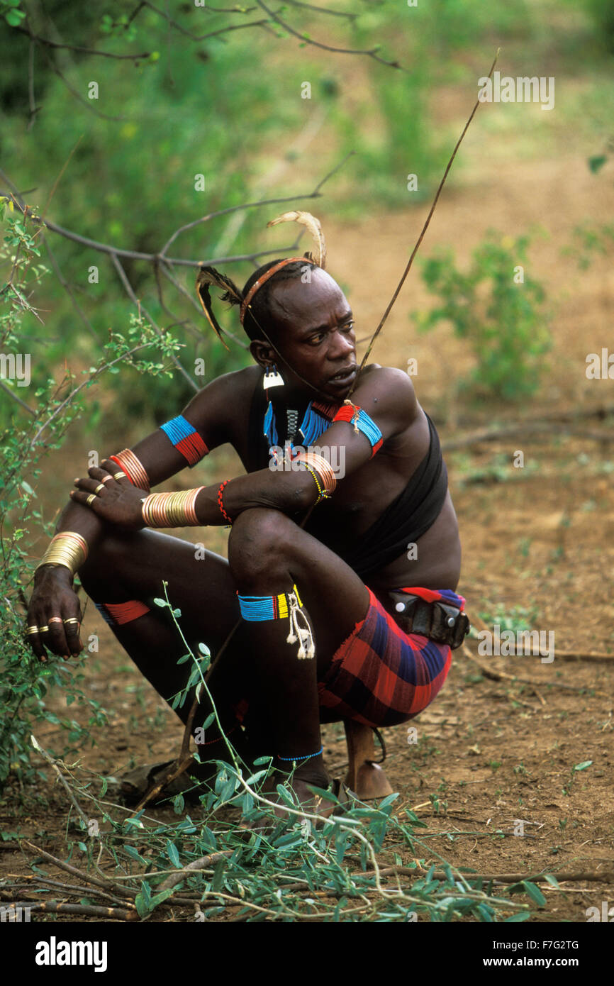 A Hamar man sits on his stool while waiting for a bull jump to begin in ...