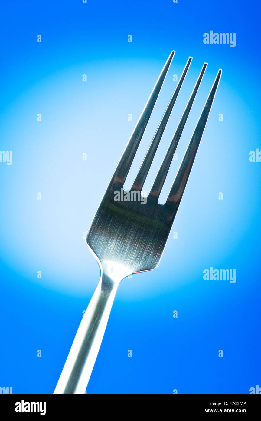Silver fork against gradient color background Stock Photo - Alamy