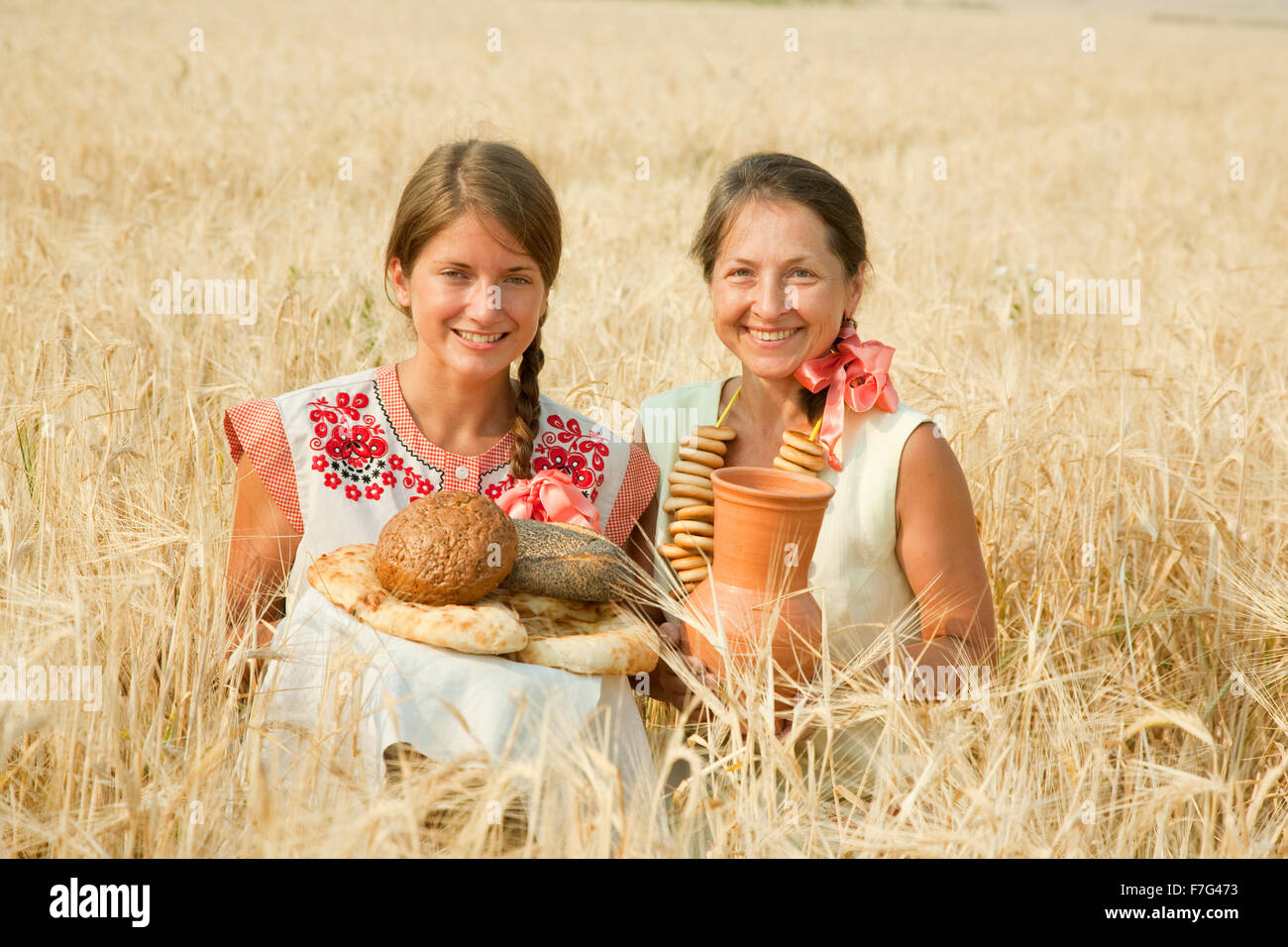 Women in traditional clothes with bread at rye field Stock Photo - Alamy