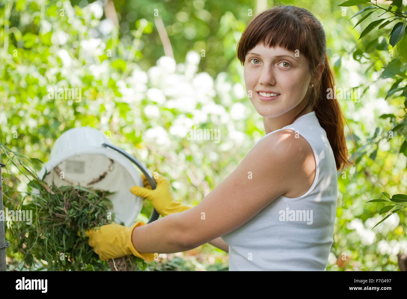 Female farmer composting grass in garden Stock Photo - Alamy