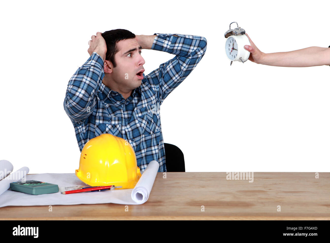 Shocked worker watching alarm clock Stock Photo - Alamy