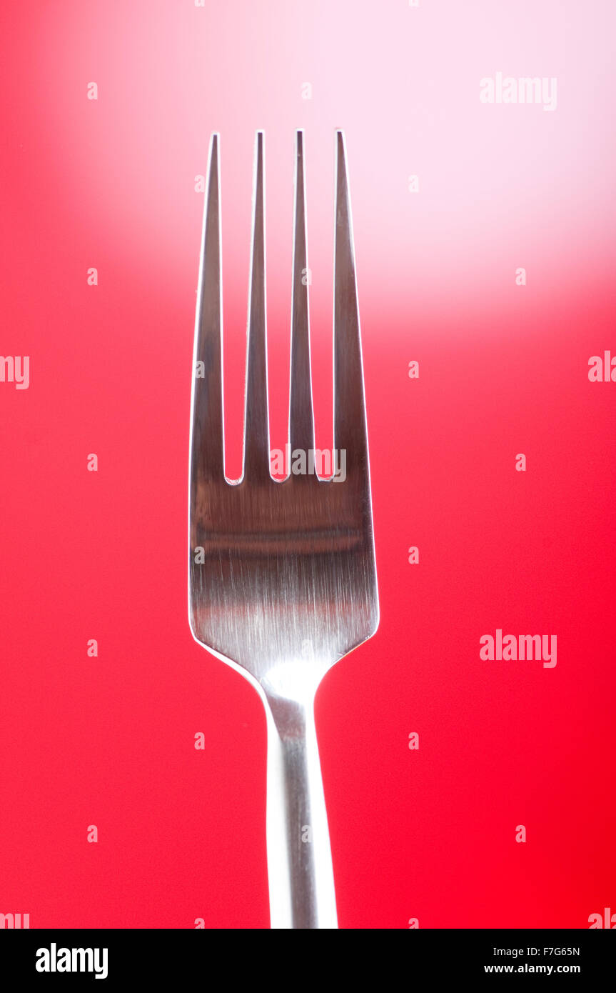 Silver fork against gradient color background Stock Photo - Alamy