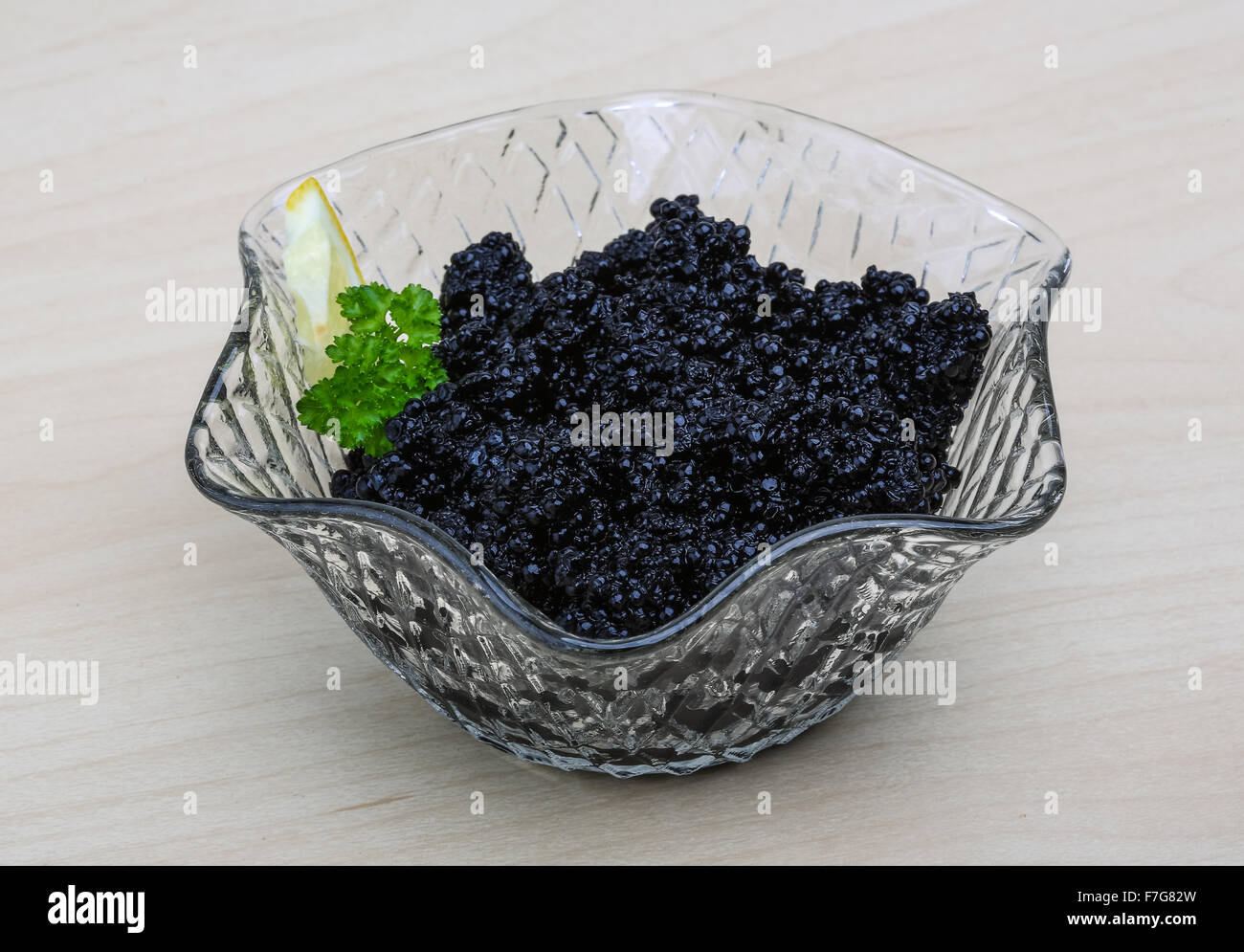 Luxury Black caviar with green herb and lemon Stock Photo - Alamy
