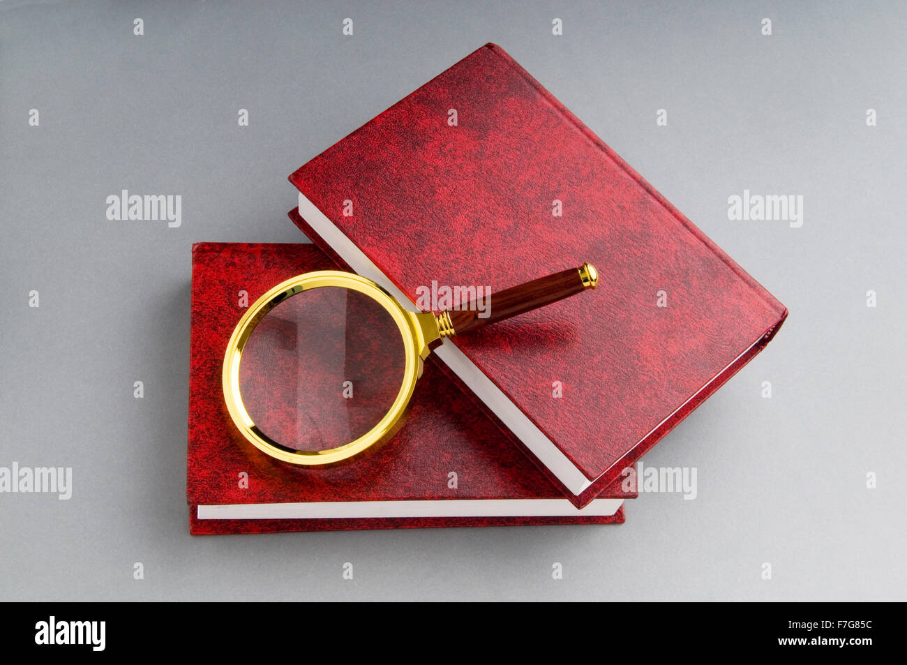 Magnifying glass over the stack of books Stock Photo - Alamy