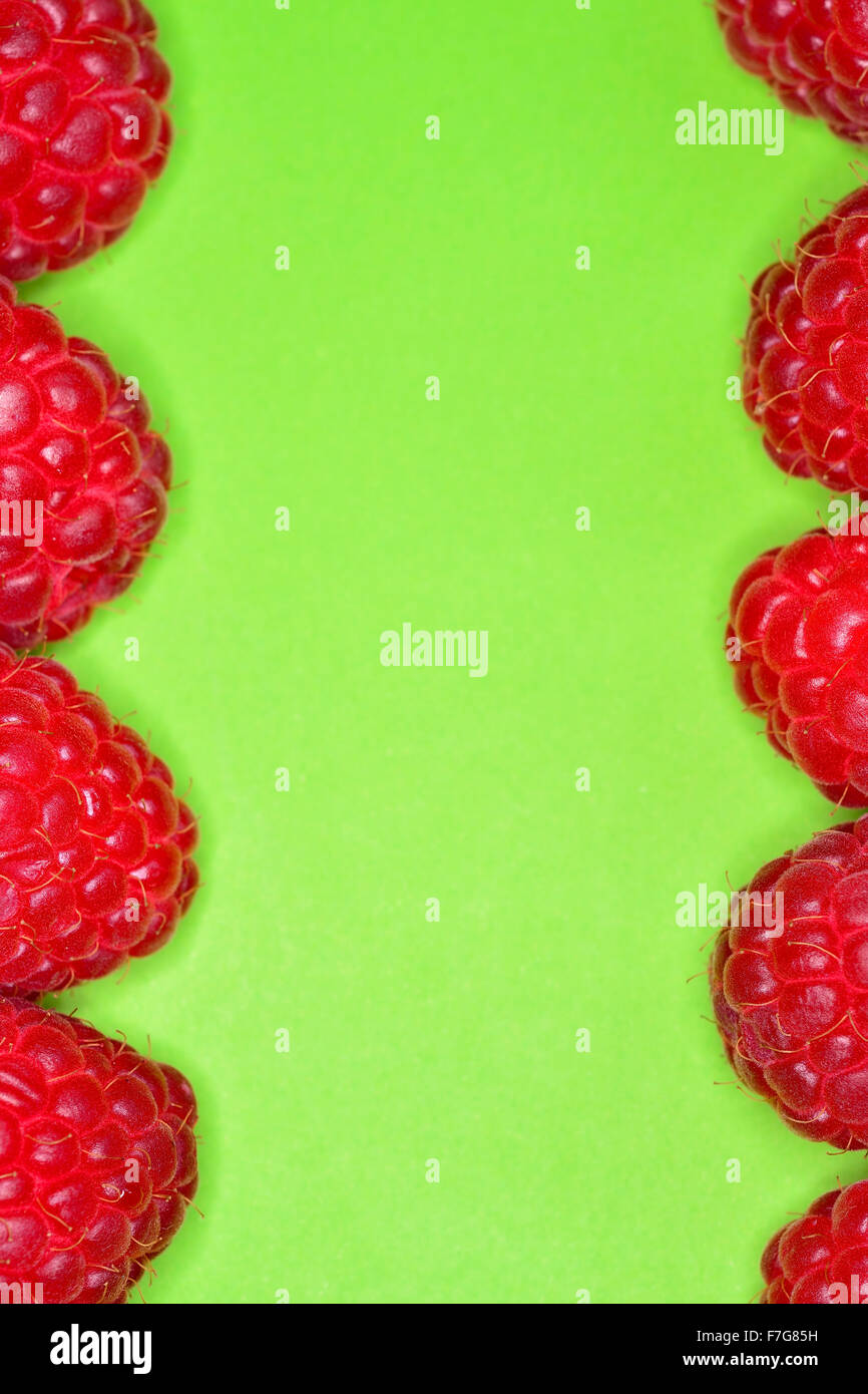 Red Raspberry border on green Stock Photo - Alamy