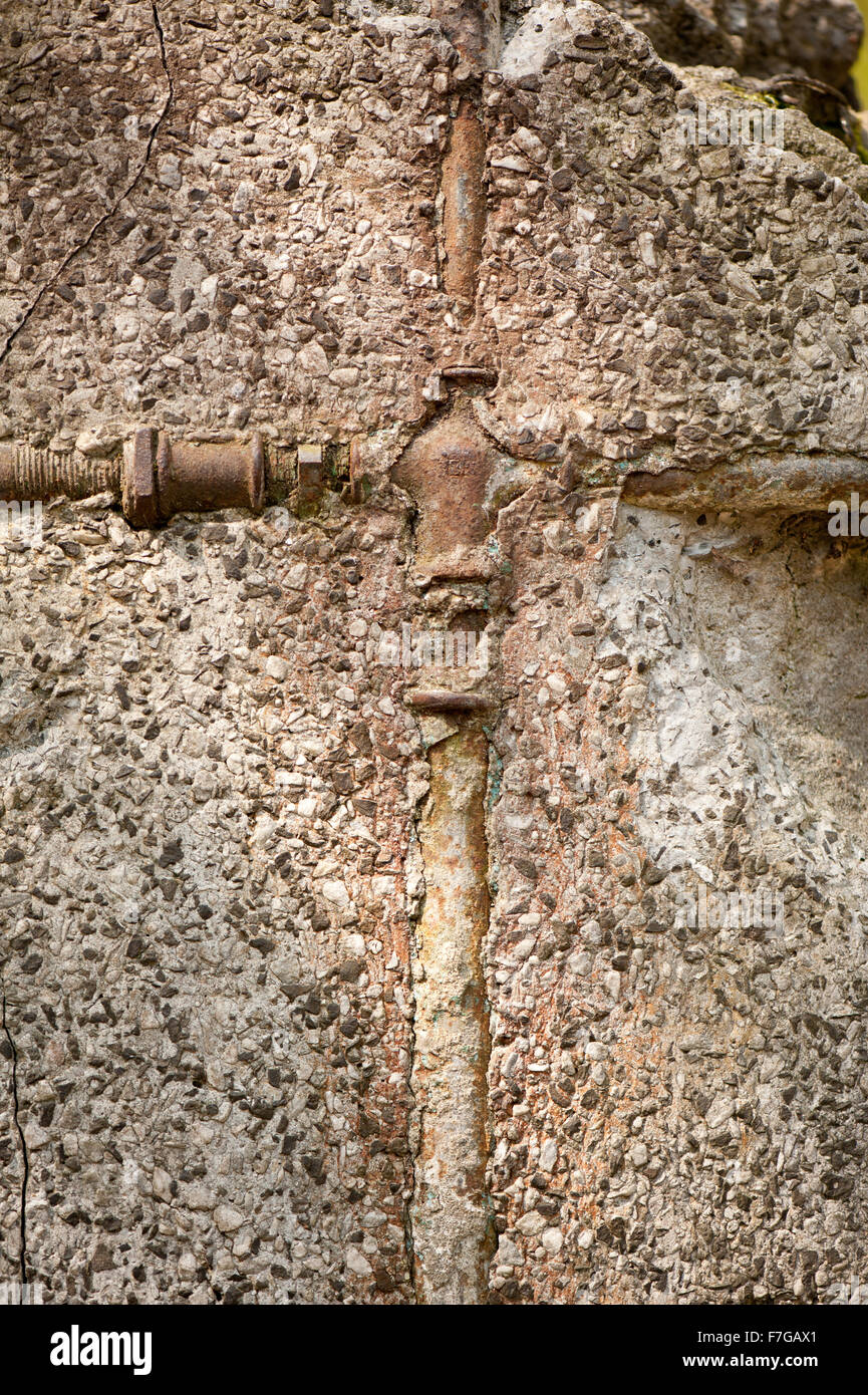 Rusty tube cross in stone, symbolic detail, metal object crossed in ...