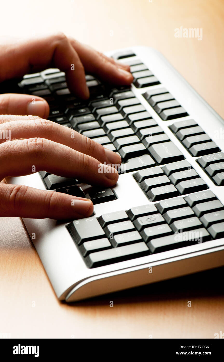 Two hands working on the silver keyboard Stock Photo - Alamy