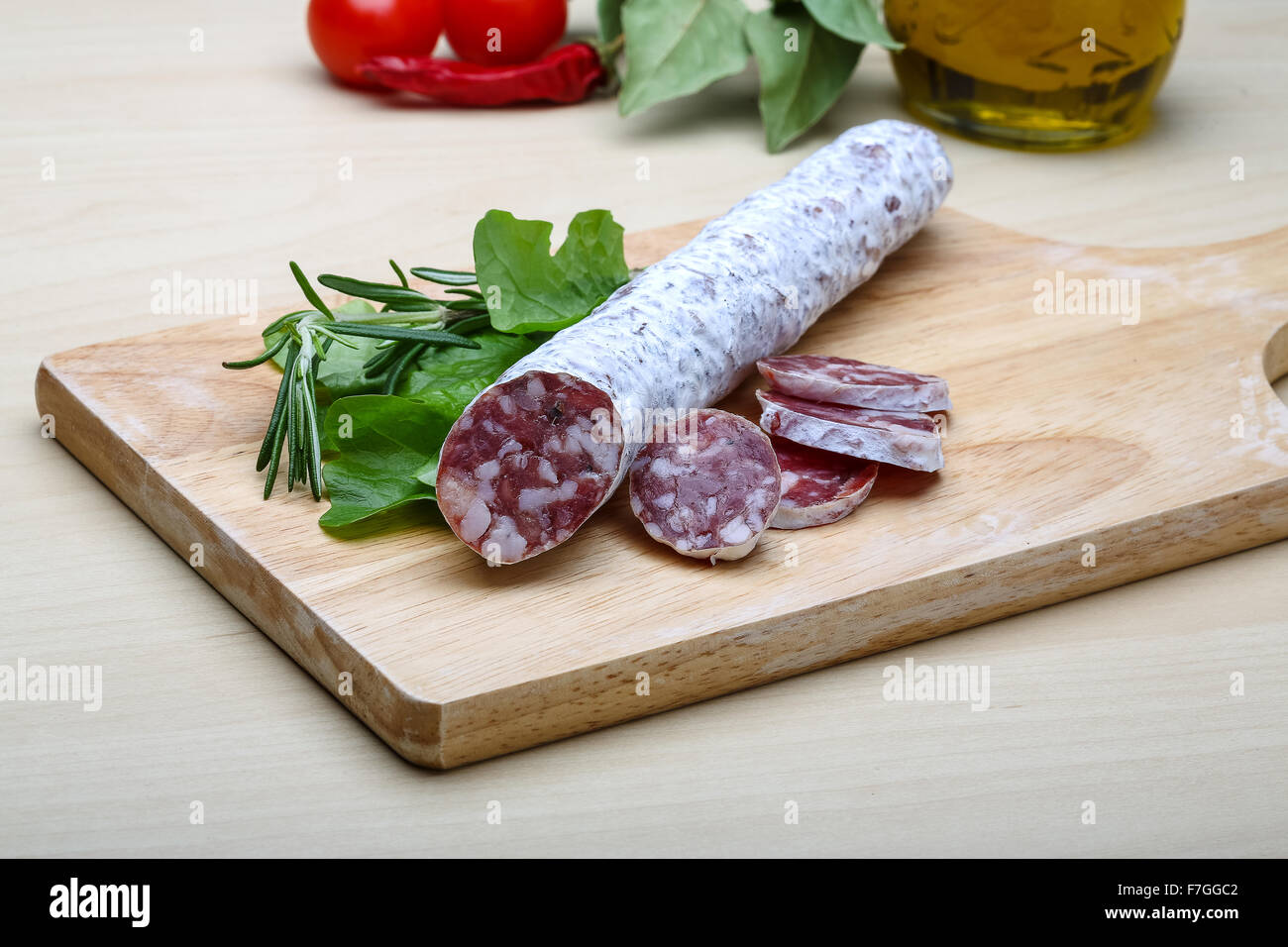 Spanish sausage - fuet salami with rosemary and salad Stock Photo - Alamy