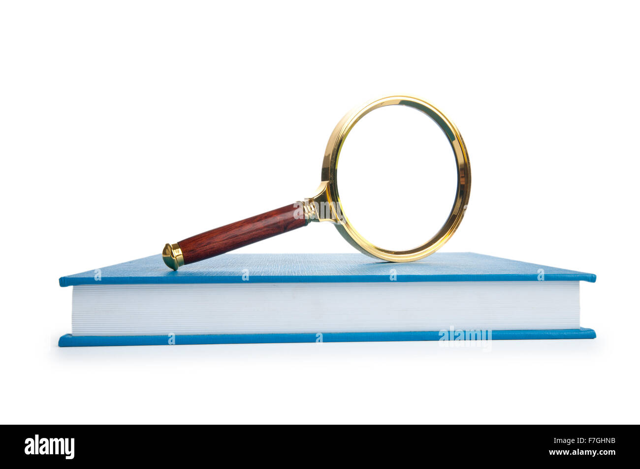Magnifying glass over the stack of books Stock Photo - Alamy