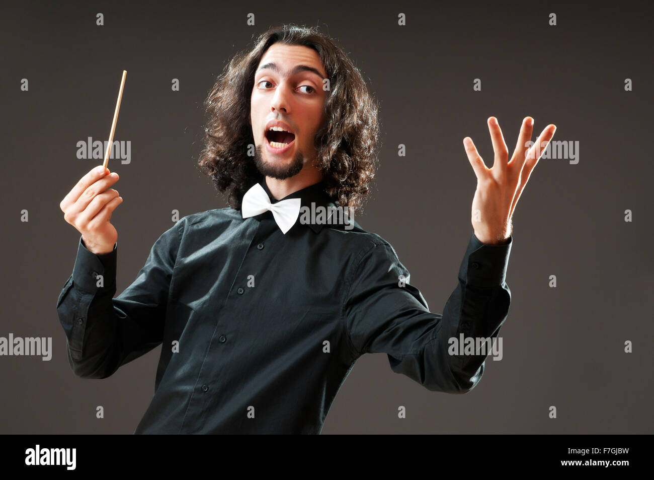 Funny conductor against dark background Stock Photo - Alamy