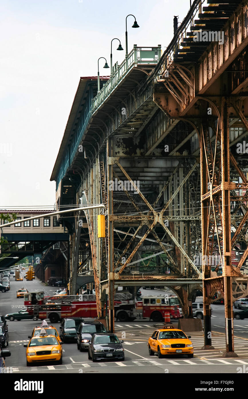 NEW YORK - JUN 22: Elevated train tracks and station buildings cast the ...