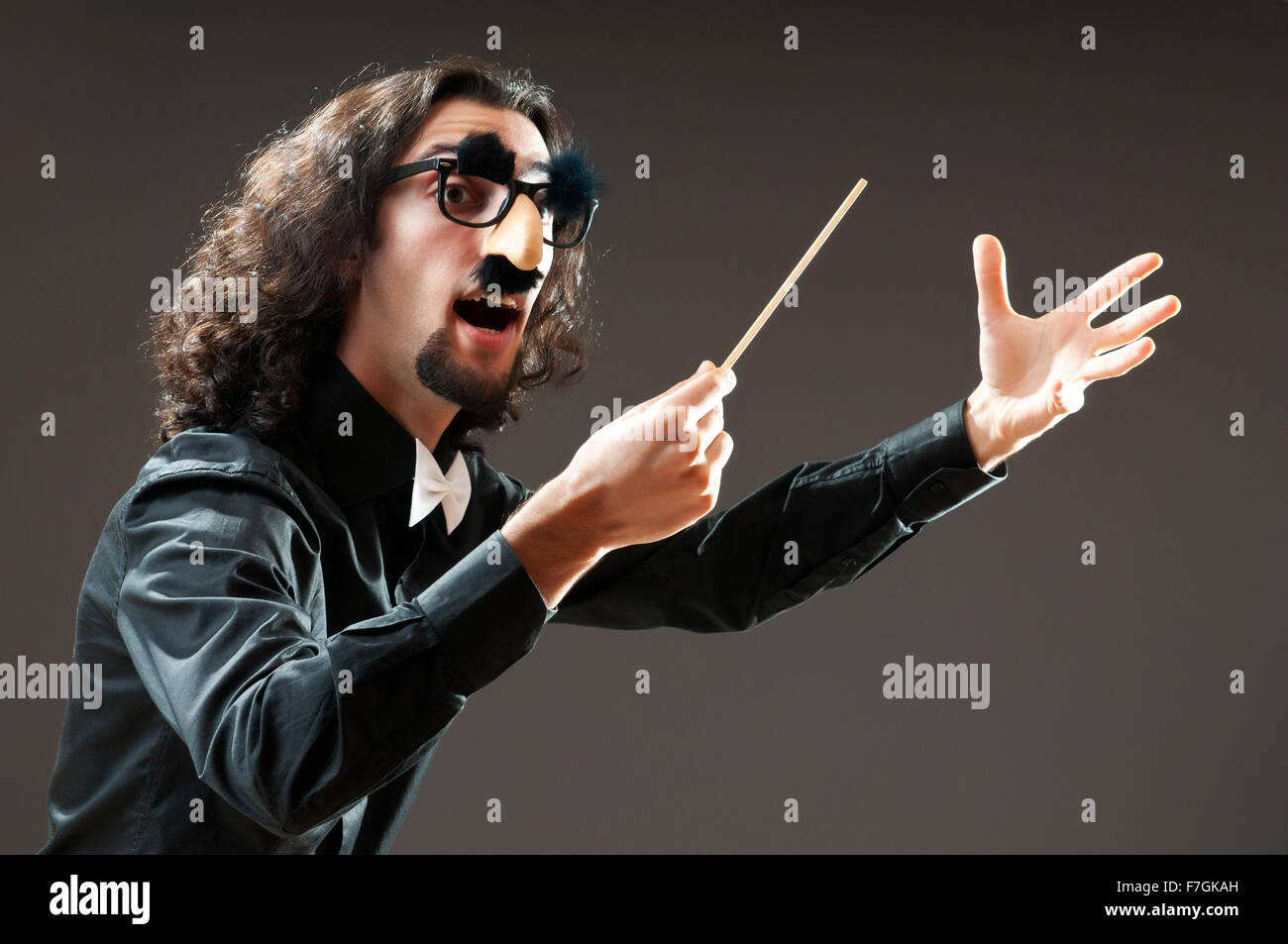 Funny conductor against dark background Stock Photo - Alamy