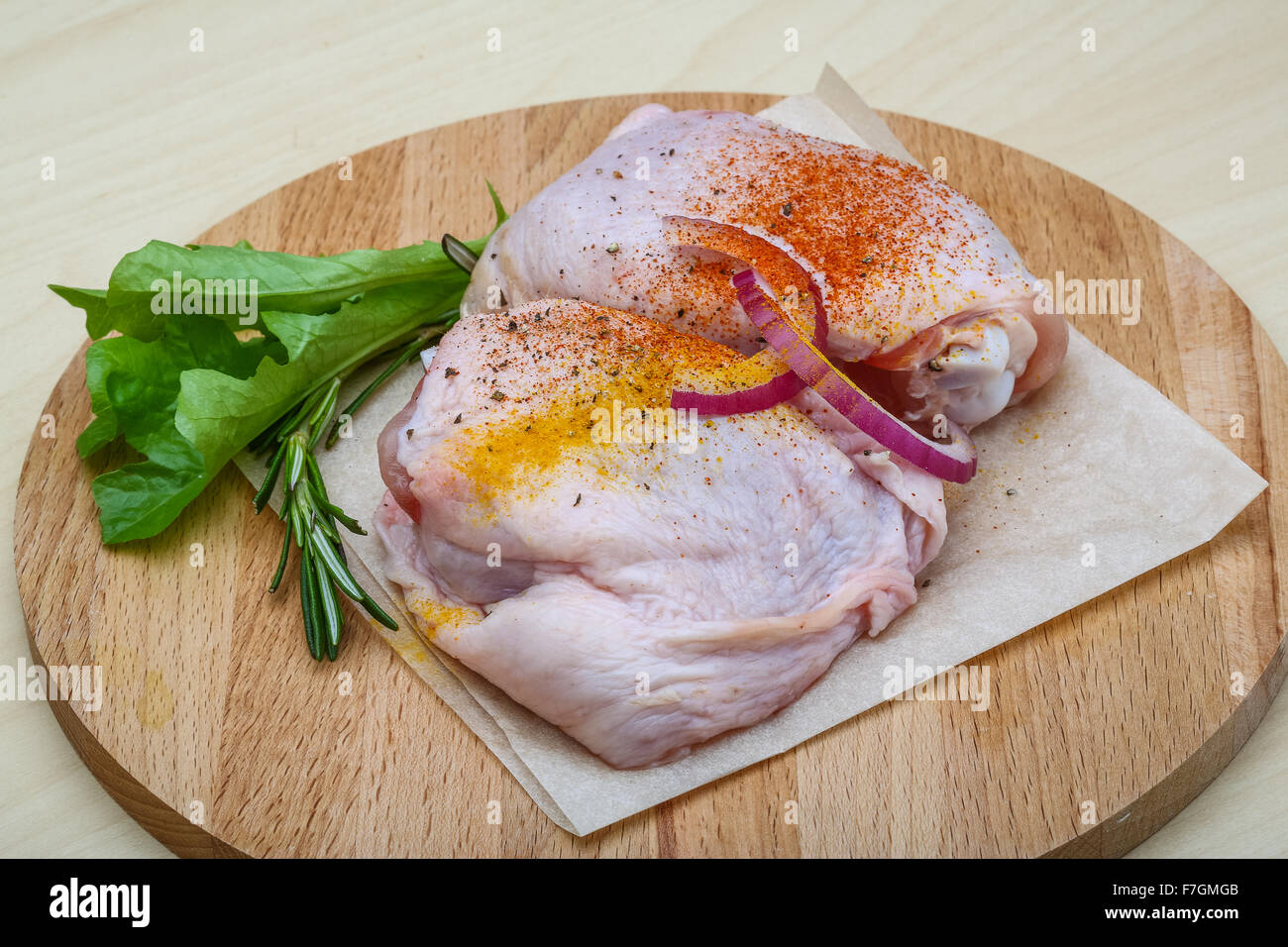 Two Raw chicken thights with herbs and spices Stock Photo - Alamy
