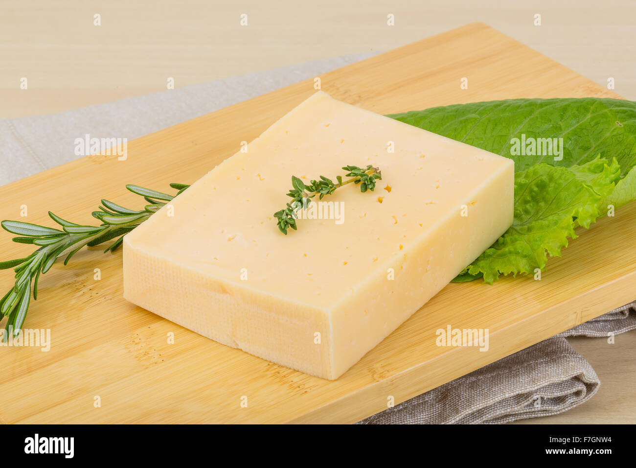 Yellow cheese brick with rosemary and thyme Stock Photo - Alamy