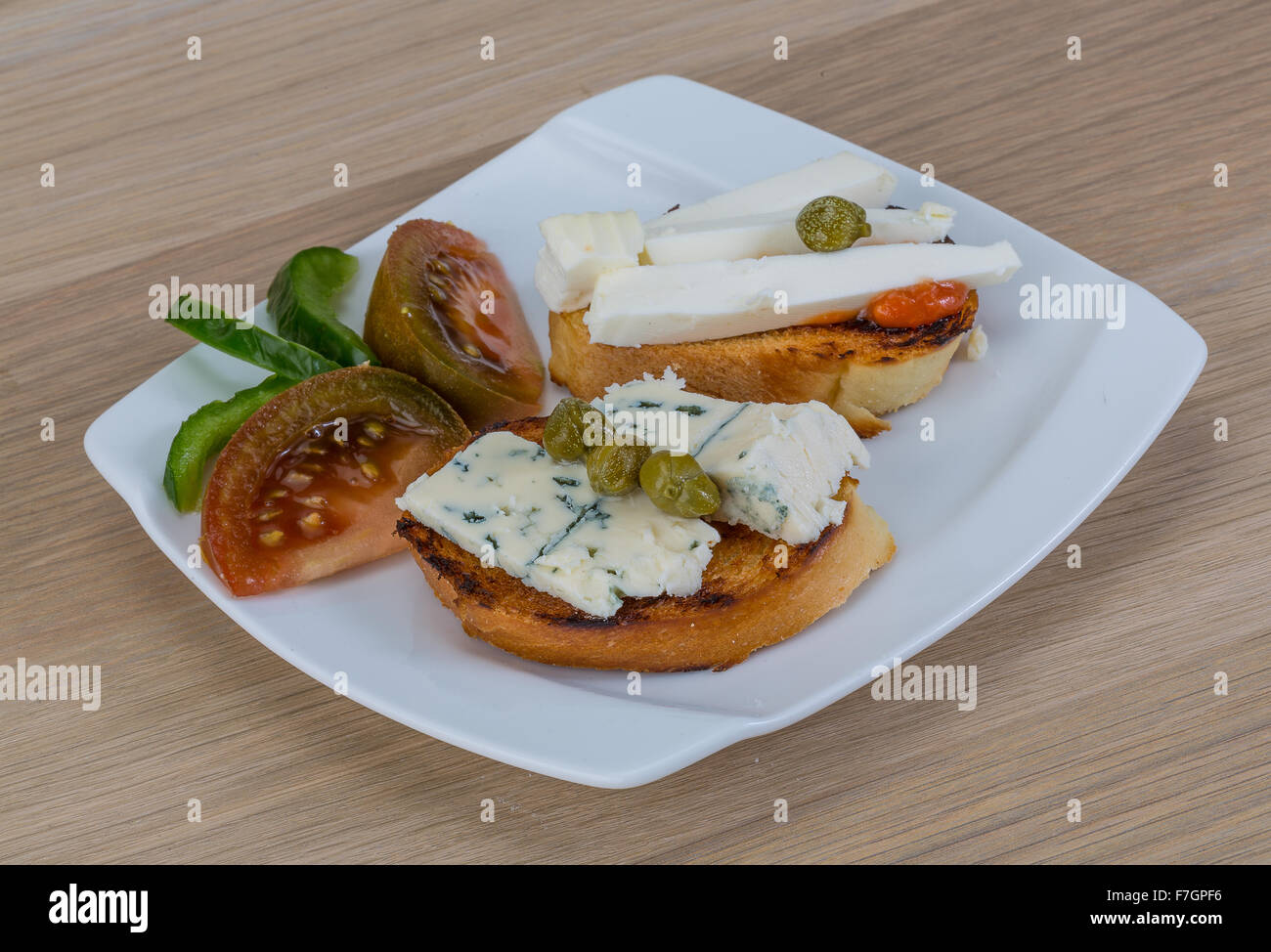 Tapas with soft blue cheese and black tomato Stock Photo - Alamy