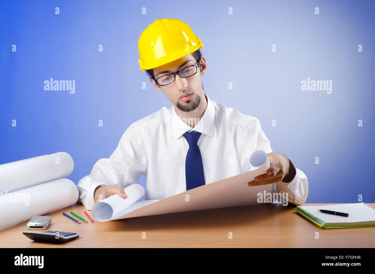 Young engineer looking at drawings Stock Photo - Alamy