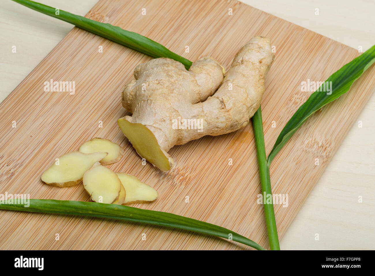Ginger root on the wood background with leaves Stock Photo - Alamy