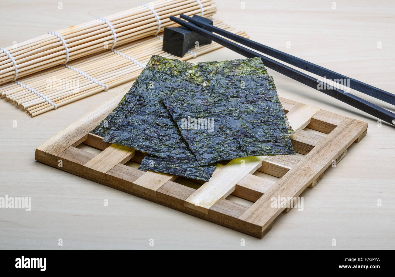 Nori sheets with sticks on the wood background Stock Photo - Alamy