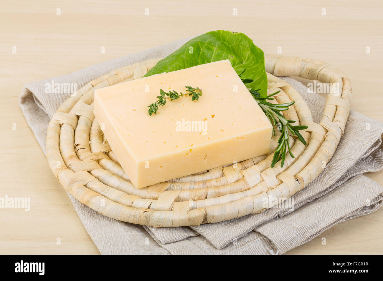 Yellow cheese brick with rosemary and thyme Stock Photo - Alamy