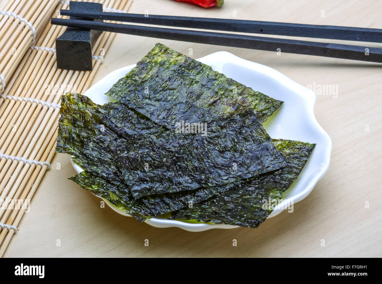 Nori sheets with sticks on the wood background Stock Photo - Alamy