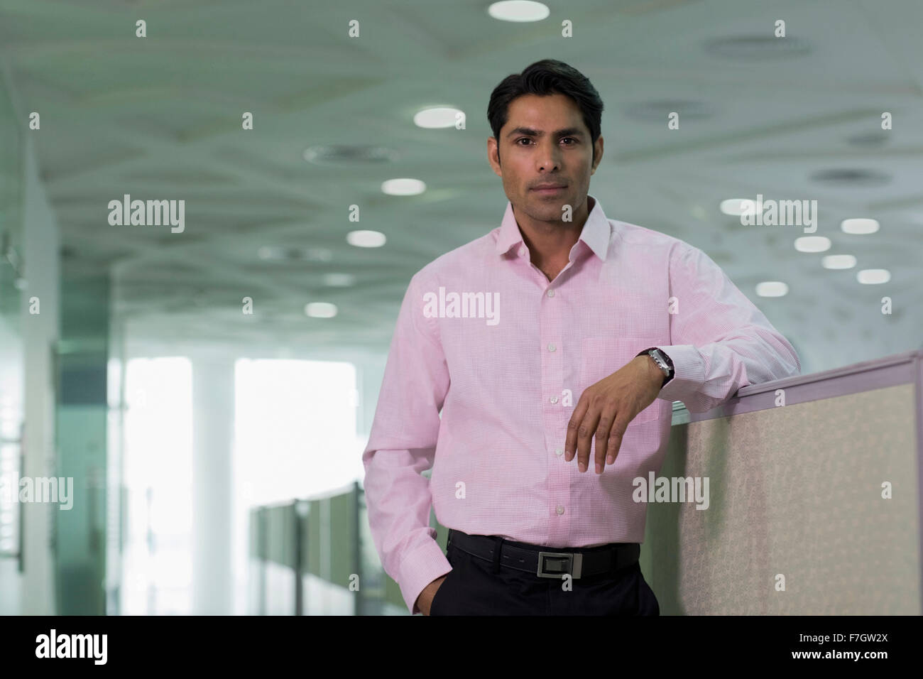 Businessman leaning on partition in office Stock Photo - Alamy