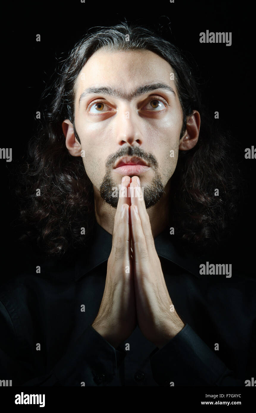 Young man praying in darkness hi-res stock photography and images - Alamy