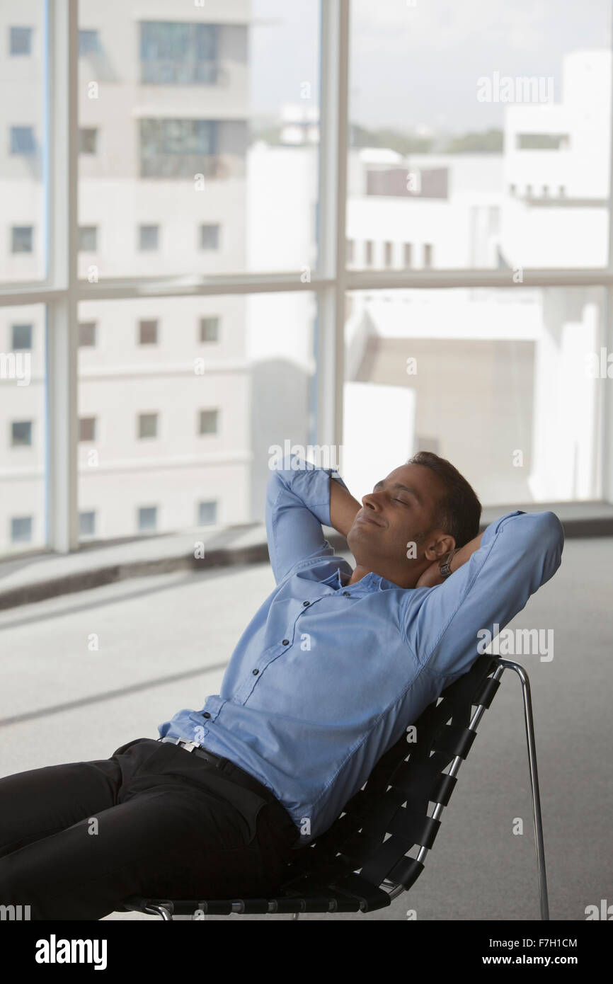 Singapore, Businessman reclining in chair in empty office Stock Photo ...