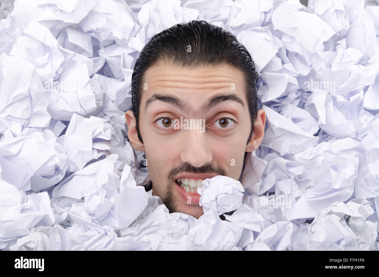 Man with lots of crumpled paper Stock Photo - Alamy