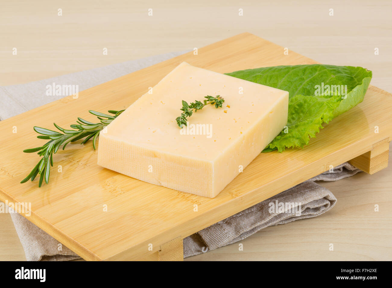 Yellow cheese brick with rosemary and thyme Stock Photo - Alamy