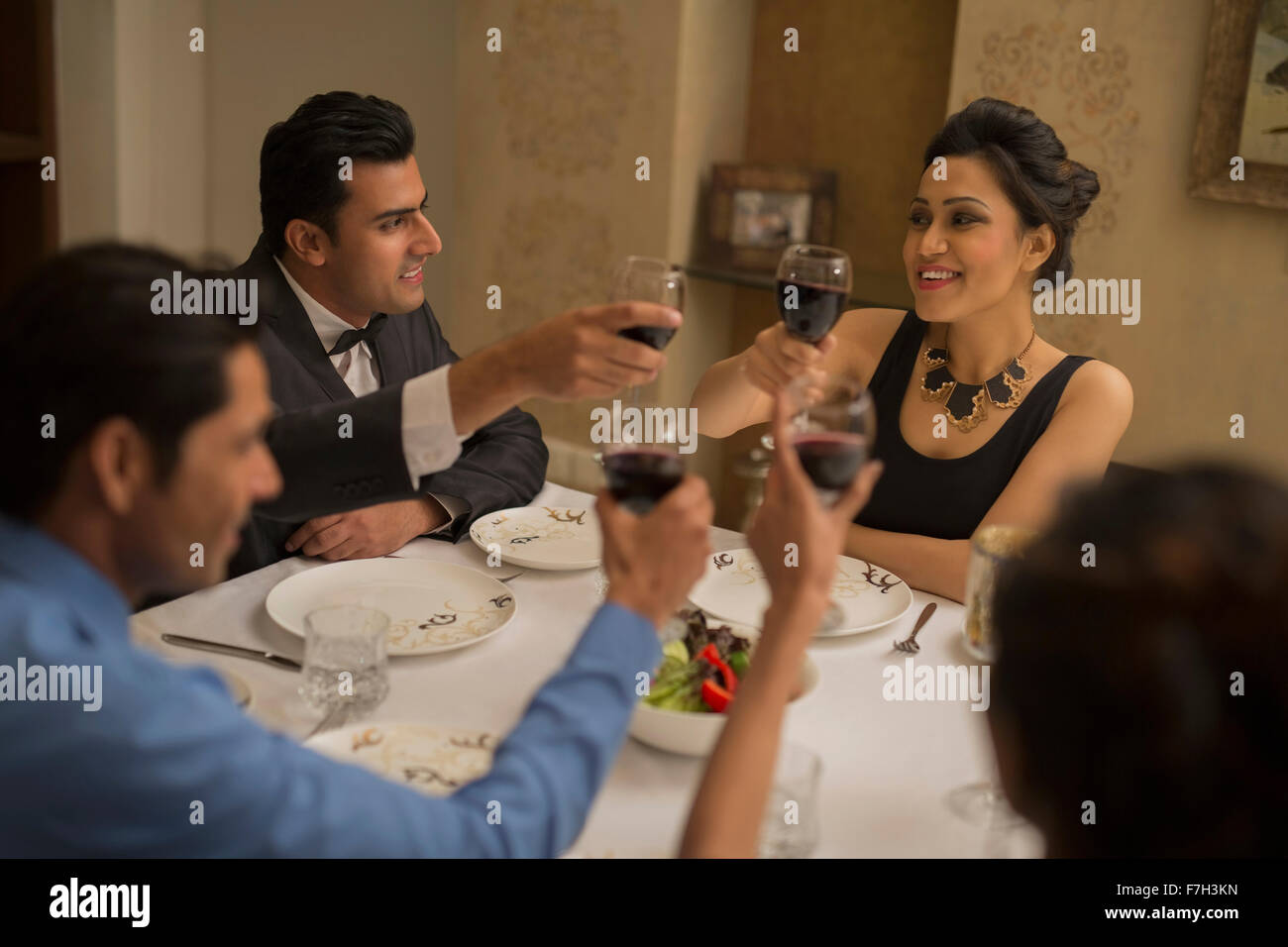 Four friends at formal dining dinner with wine glasses Stock Photo - Alamy