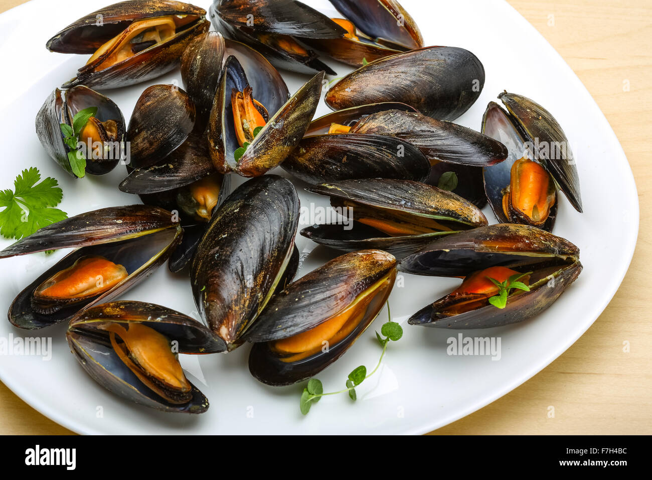 Fresh tasty Boiled mussels with herbs on wood background Stock Photo ...