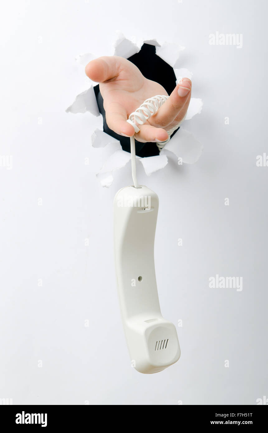 Hand holding phone through hole in paper Stock Photo - Alamy