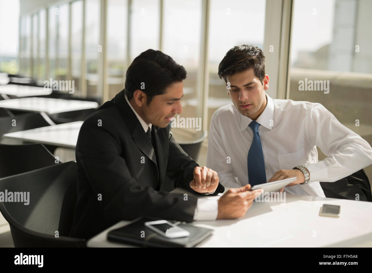 India, Two male colleagues working in cafeteria Stock Photo - Alamy