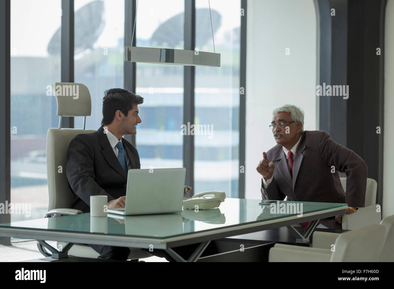 India, Senior businessman and young man discussing at meeting Stock ...