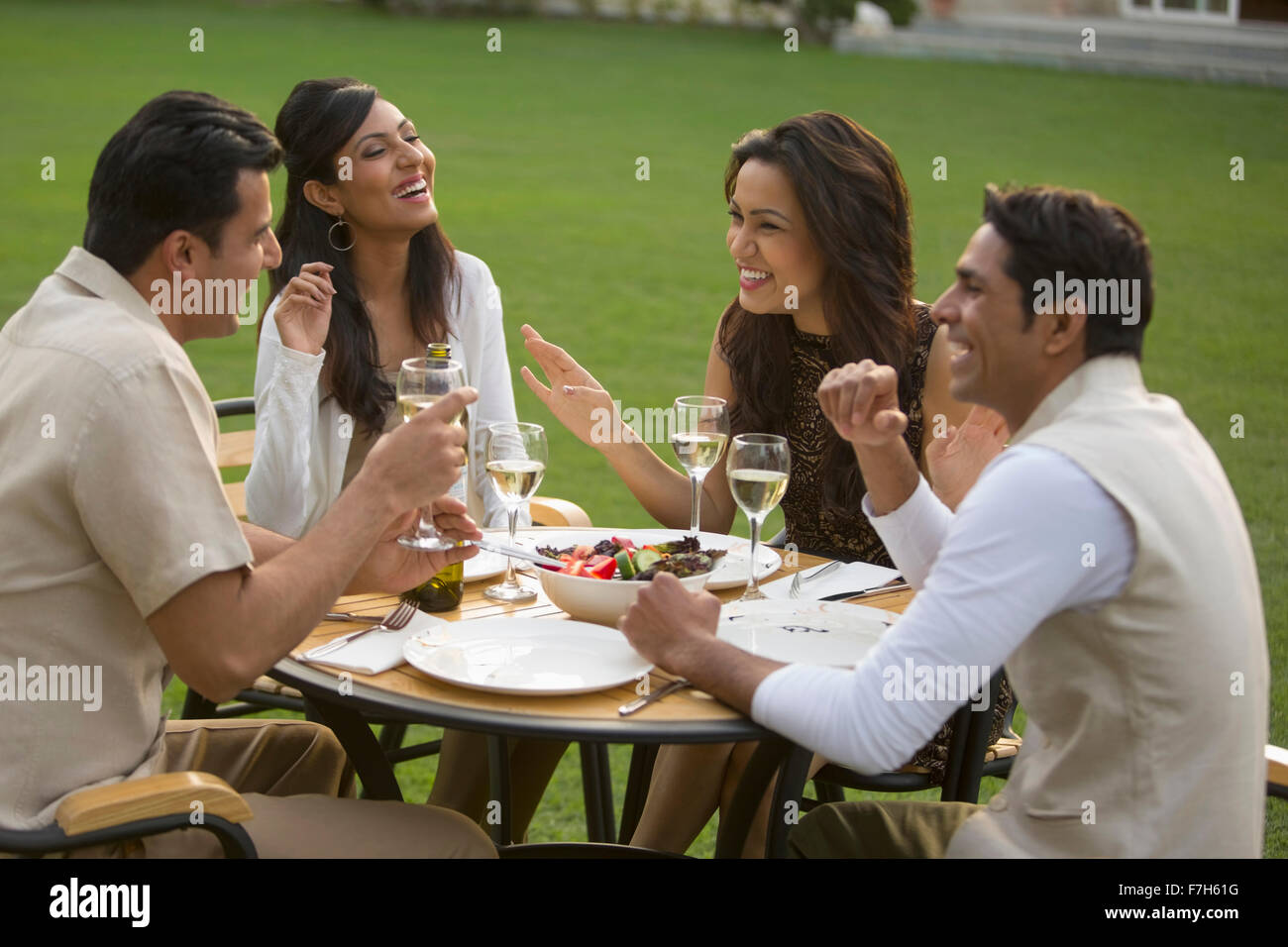 Friends dining outside, laughing Stock Photo - Alamy