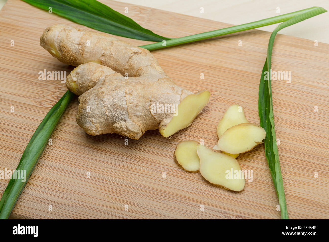 Ginger root on the wood background with leaves Stock Photo - Alamy