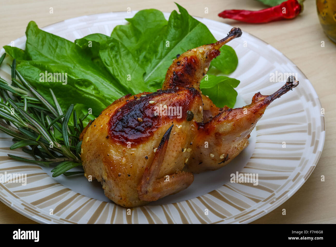 Roasted Quail with rosemary and spices on the wood background Stock ...