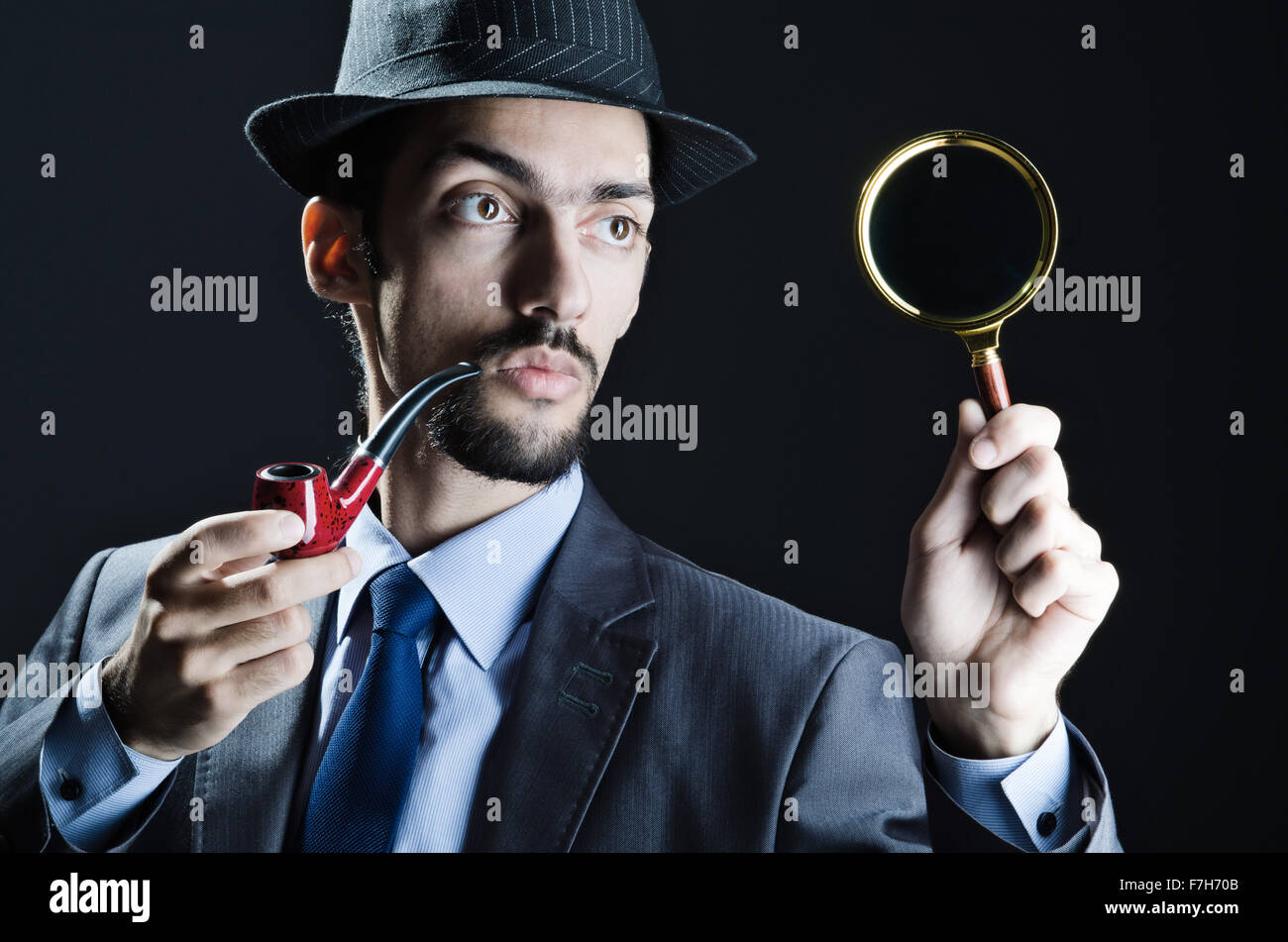 Detective with magnifying glass and pipe Stock Photo - Alamy