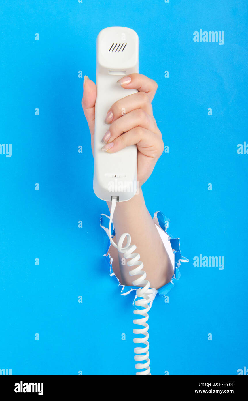 Hand with phone out of paper hole Stock Photo - Alamy