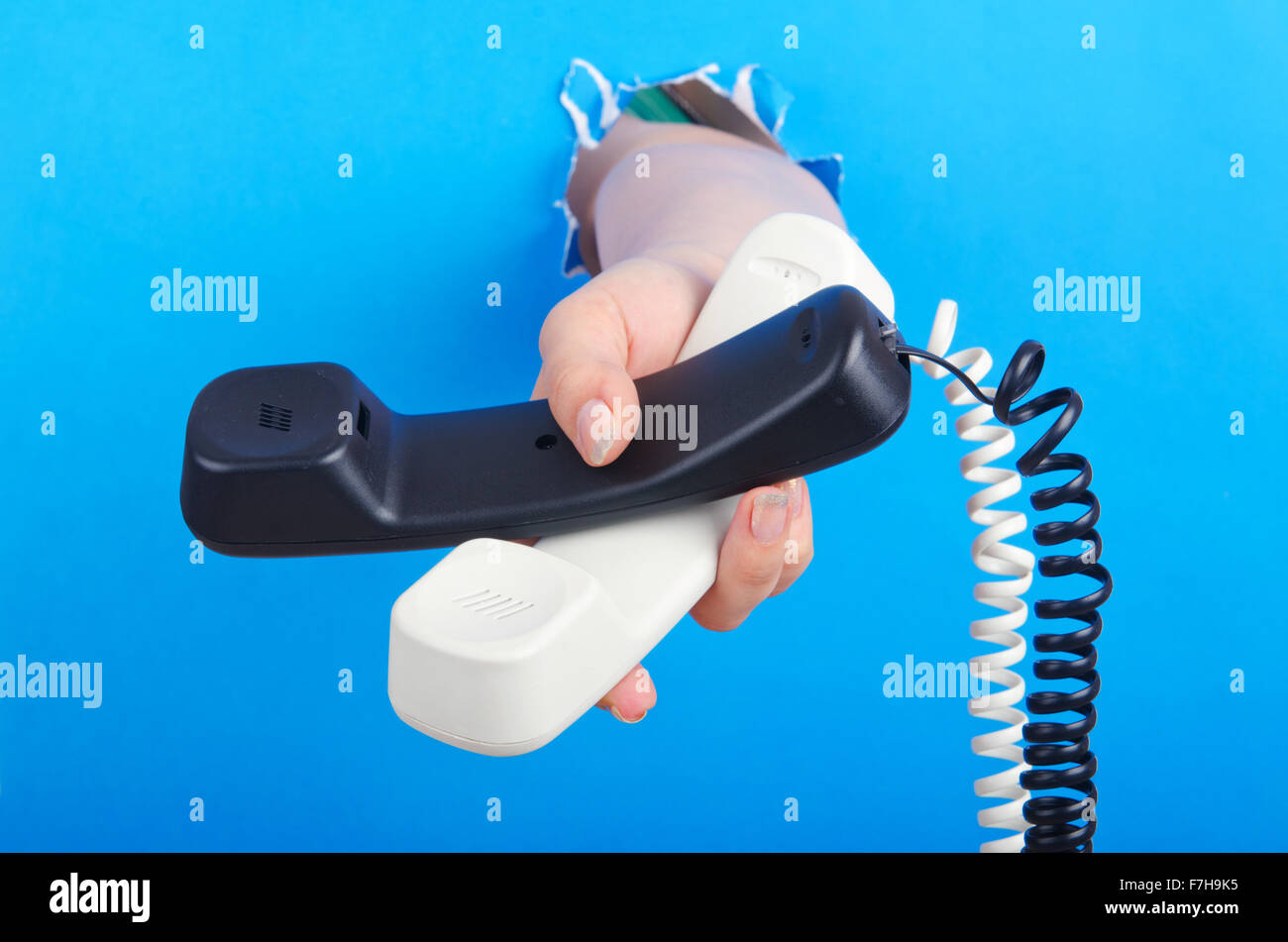 Hand with phone out of paper hole Stock Photo - Alamy