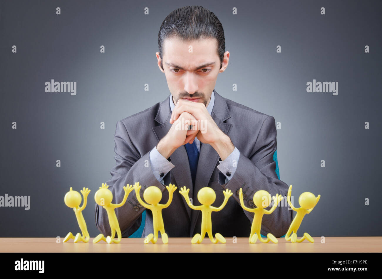 Boss with figures of his subordinates Stock Photo - Alamy