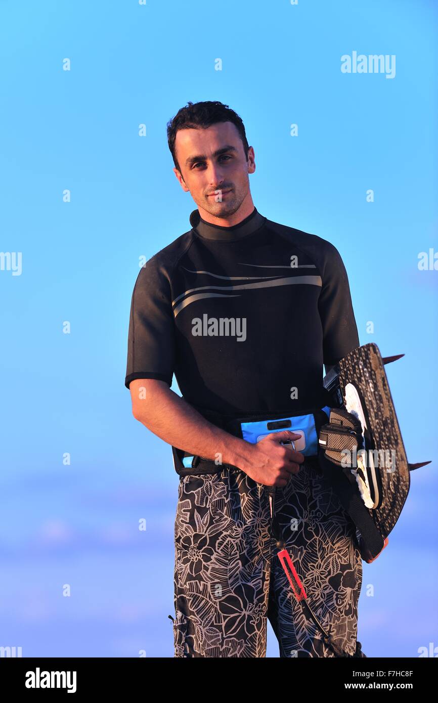 Portrait of a strong young surf man at beach on sunset in a ...