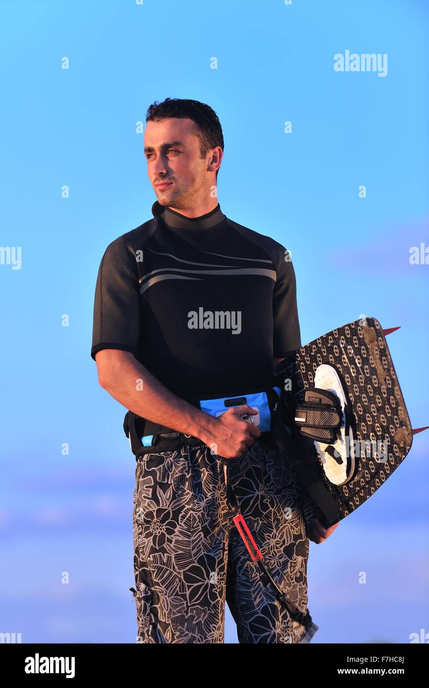 Portrait of a strong young surf man at beach on sunset in a ...