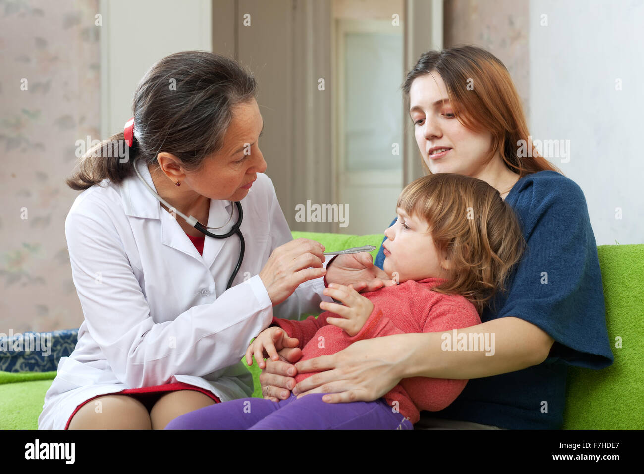 friendly mature children's doctor examining 2 years child at home Stock ...