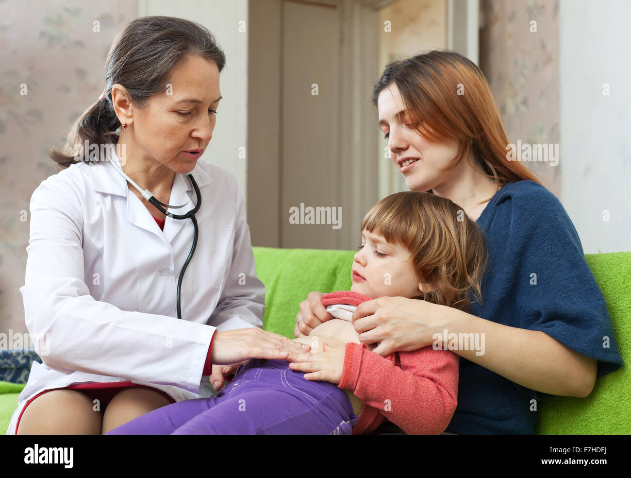 mature children's doctor examining baby in home Stock Photo - Alamy