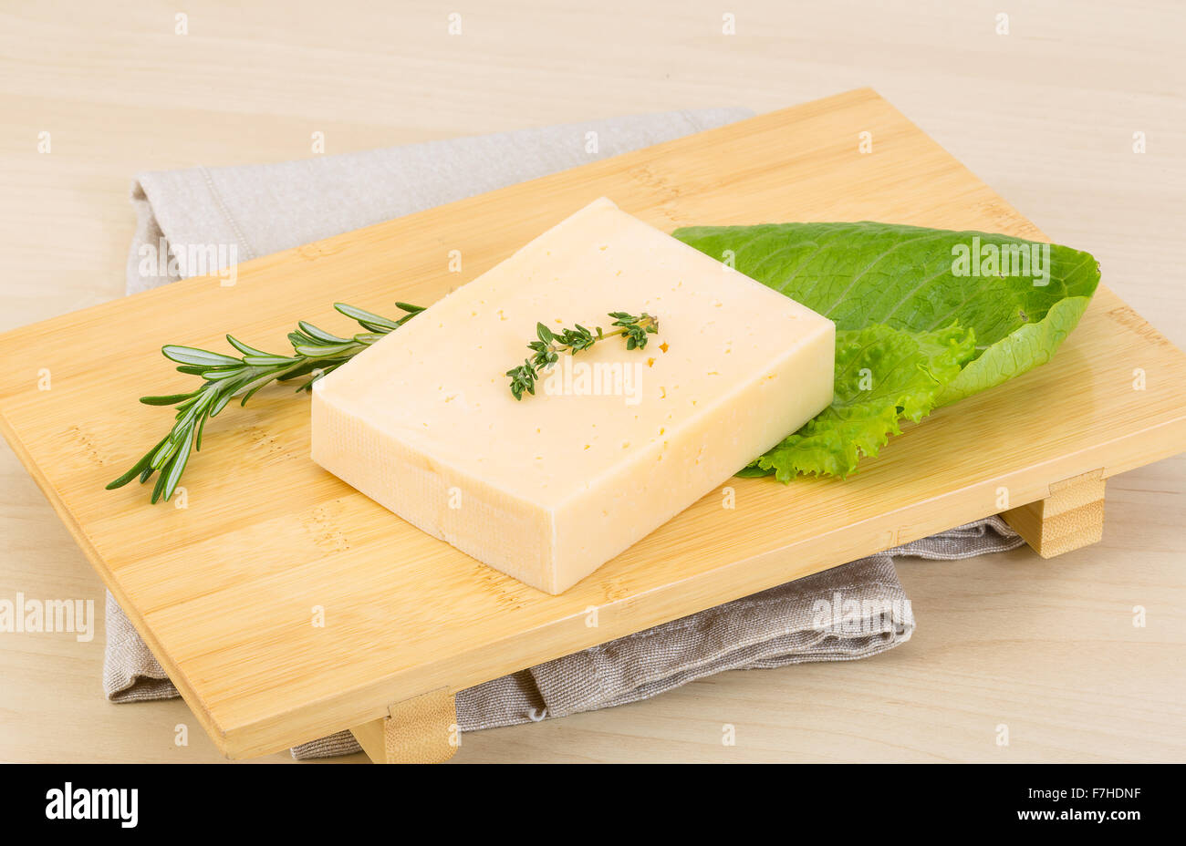 Yellow cheese brick with rosemary and thyme Stock Photo - Alamy