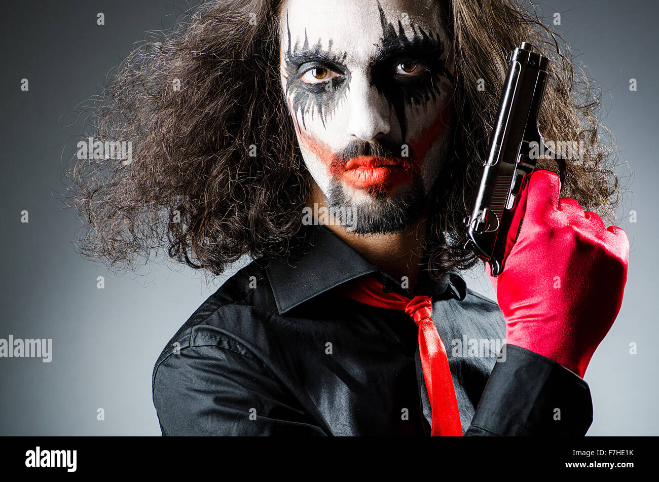 Evil clown with gun in dark room Stock Photo - Alamy