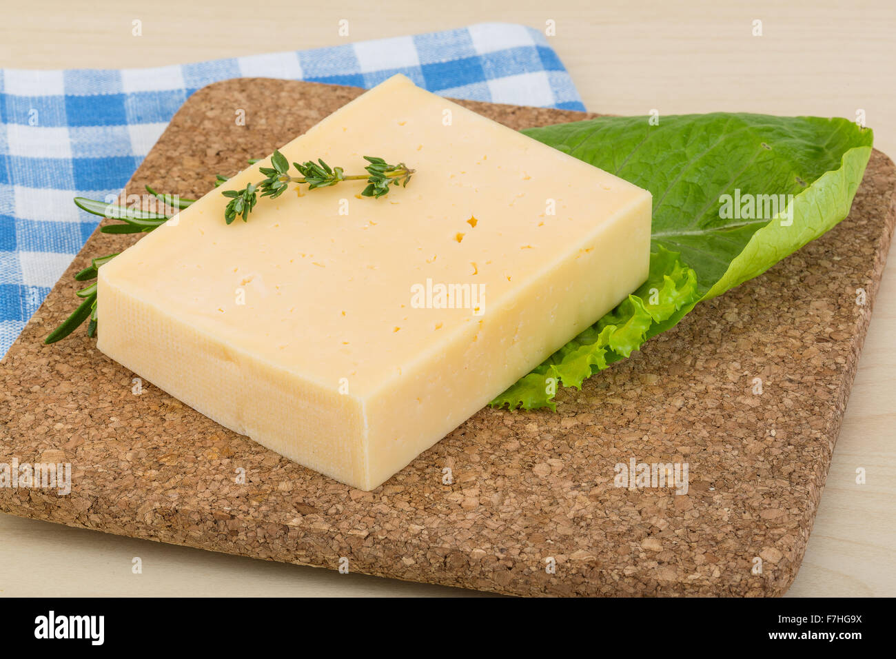 Yellow cheese brick with rosemary and thyme Stock Photo - Alamy
